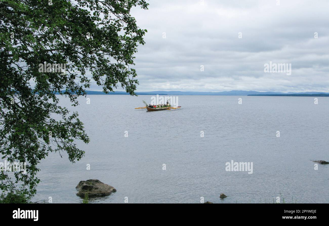 Midsummer in Dalarna people in costume rowing a church boat on lake ...