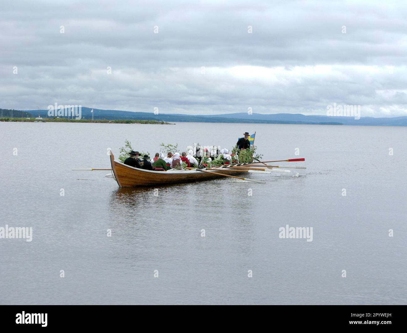 Midsummer in Dalarna people in costume rowing a church boat on lake ...
