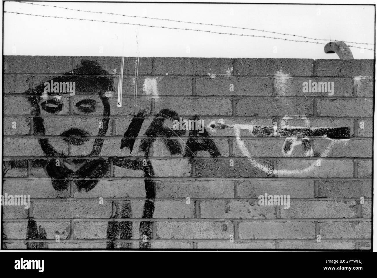 " Ireland, Dublin Graffiti. Wall of stones with barbed wire above it ...