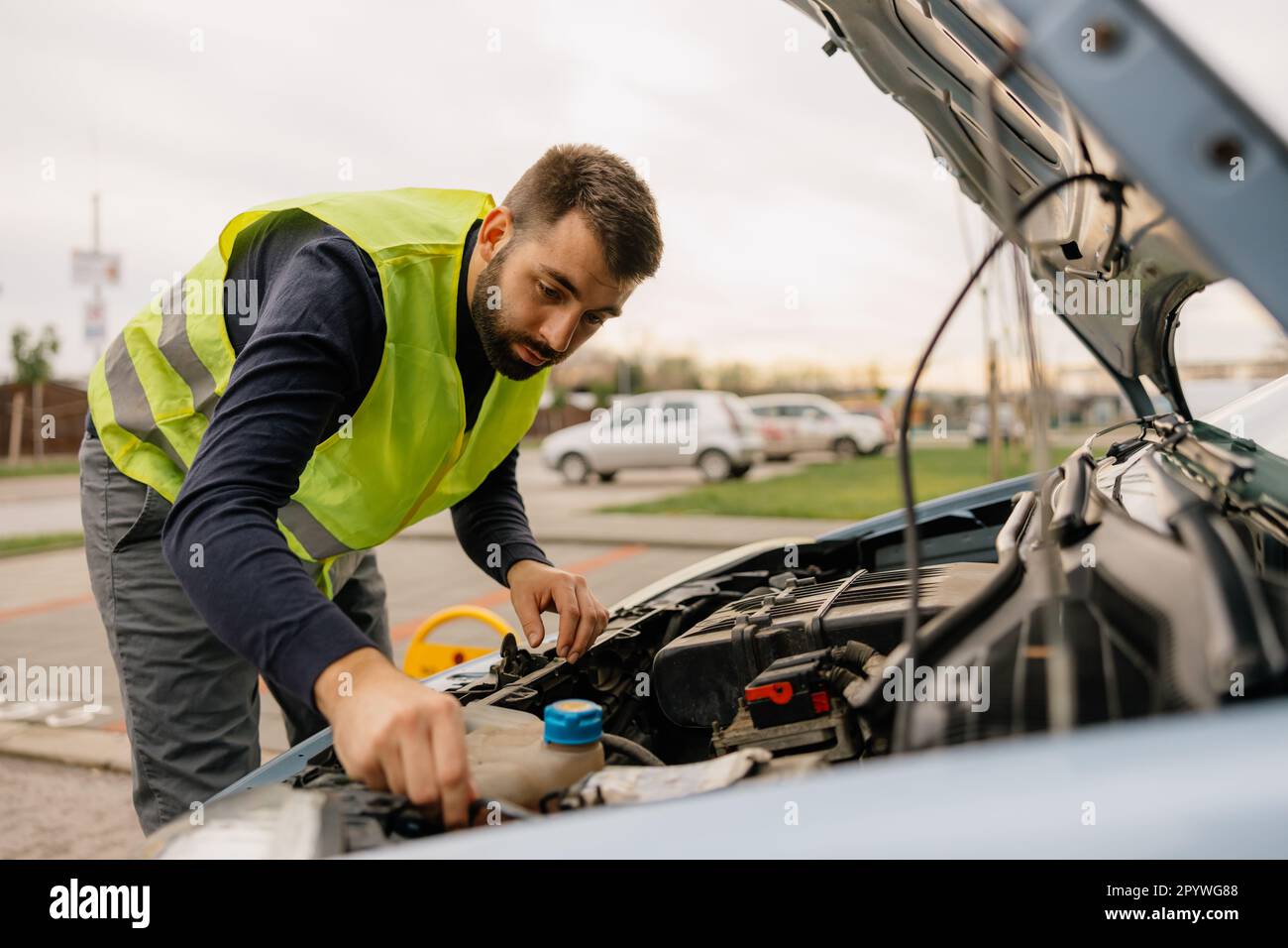 A Man is standing next to his car formally dressed and looking worried ...