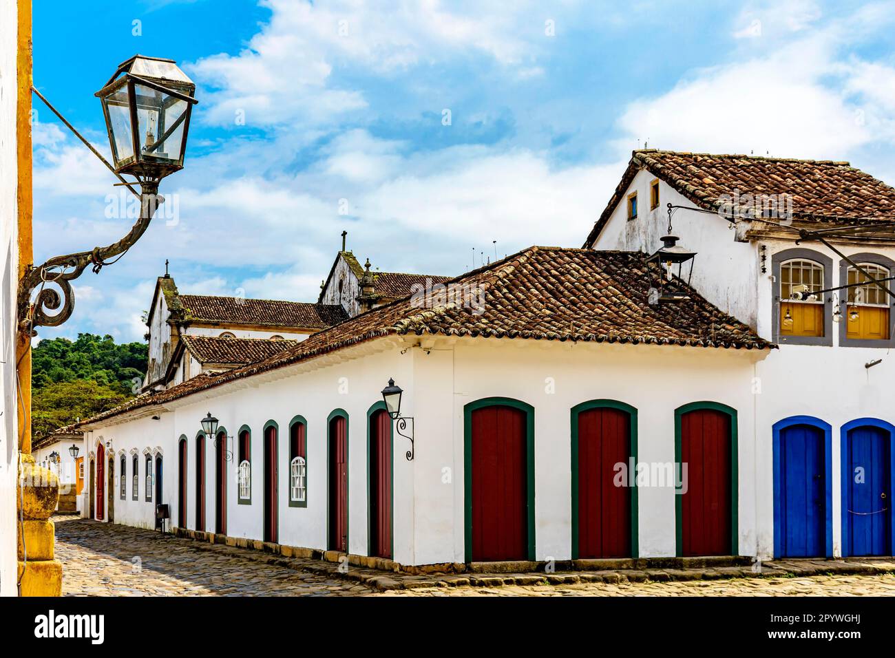 Cobblestone streets and house facades with old colonial-style lanterns ...