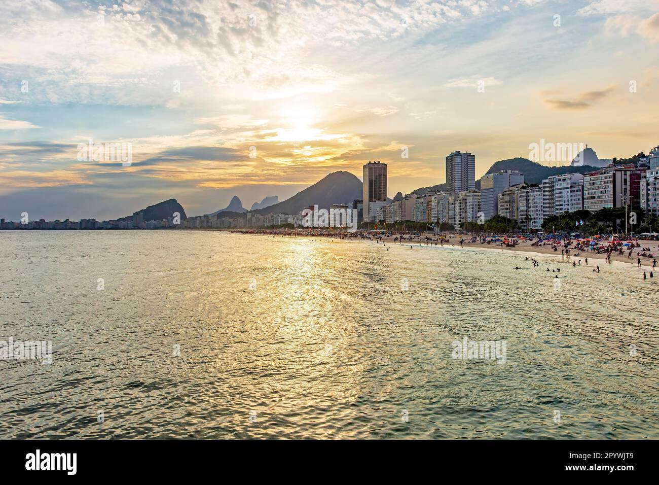 Sunset on the famous Copacabana beach with the sea, sand, mountains and ...