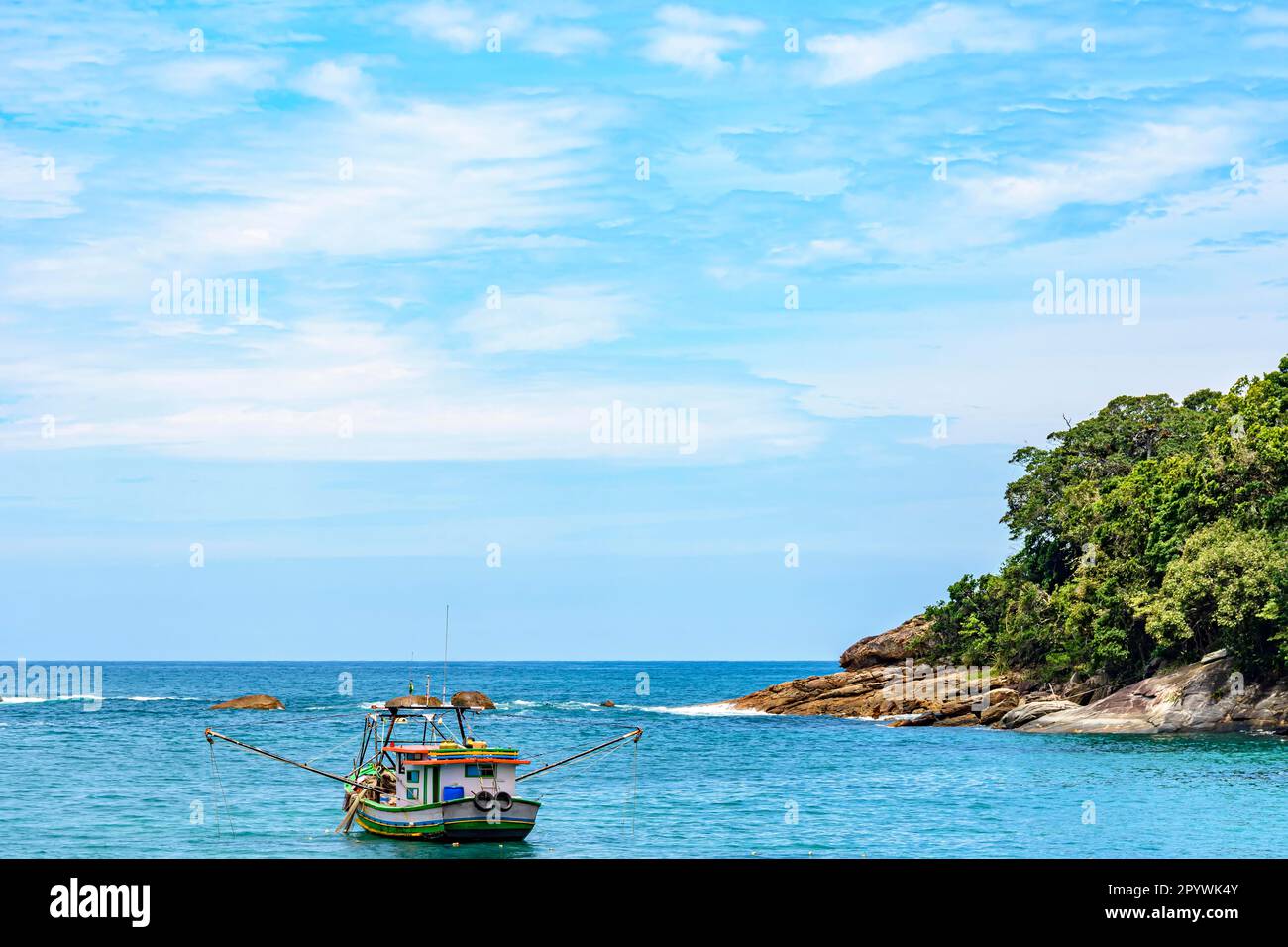 Trawler anchored alongside the tropical rainforest in the Trindade sea ...