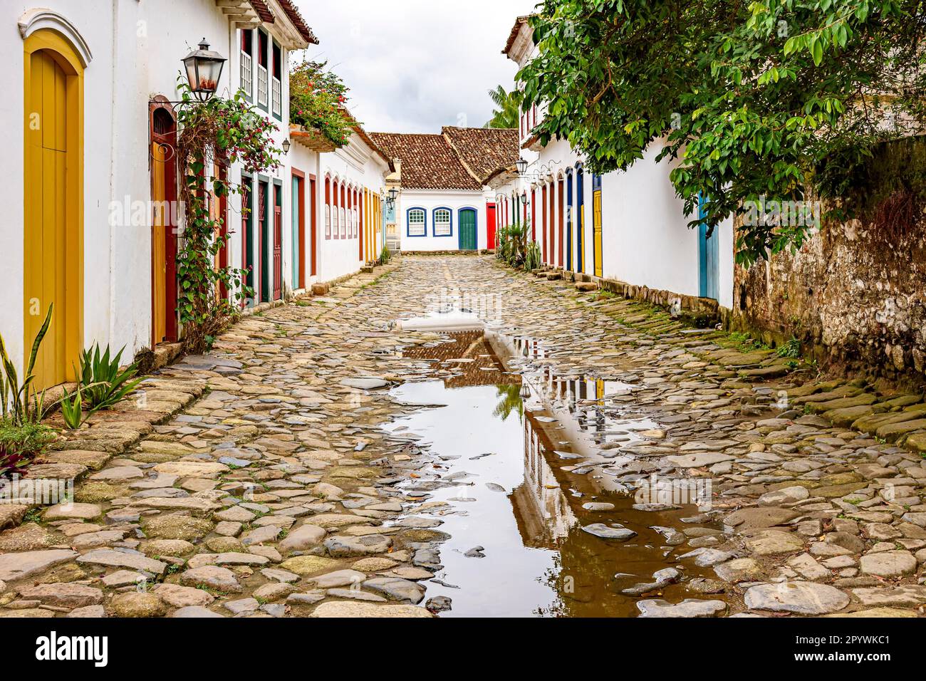 Cobblestone street with colorful colonial houses and reflections in the ...