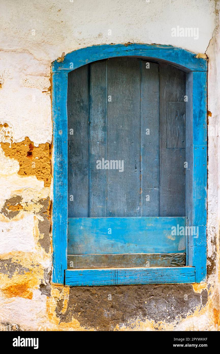 Old and deteriorated wooden window painted in blue in the historic city ...
