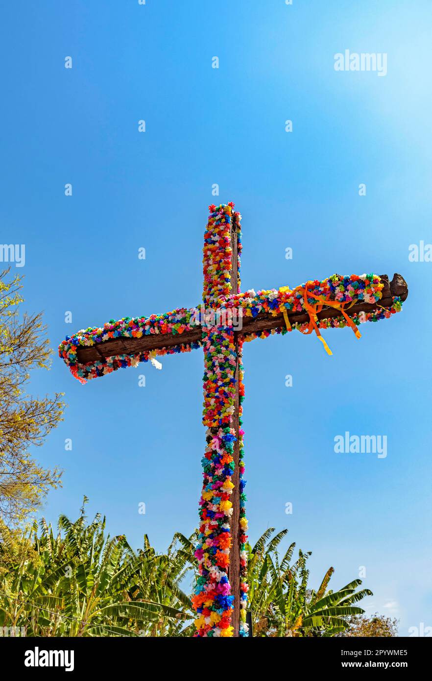Crucifix decorated with flowers with blue sky in the background common ...
