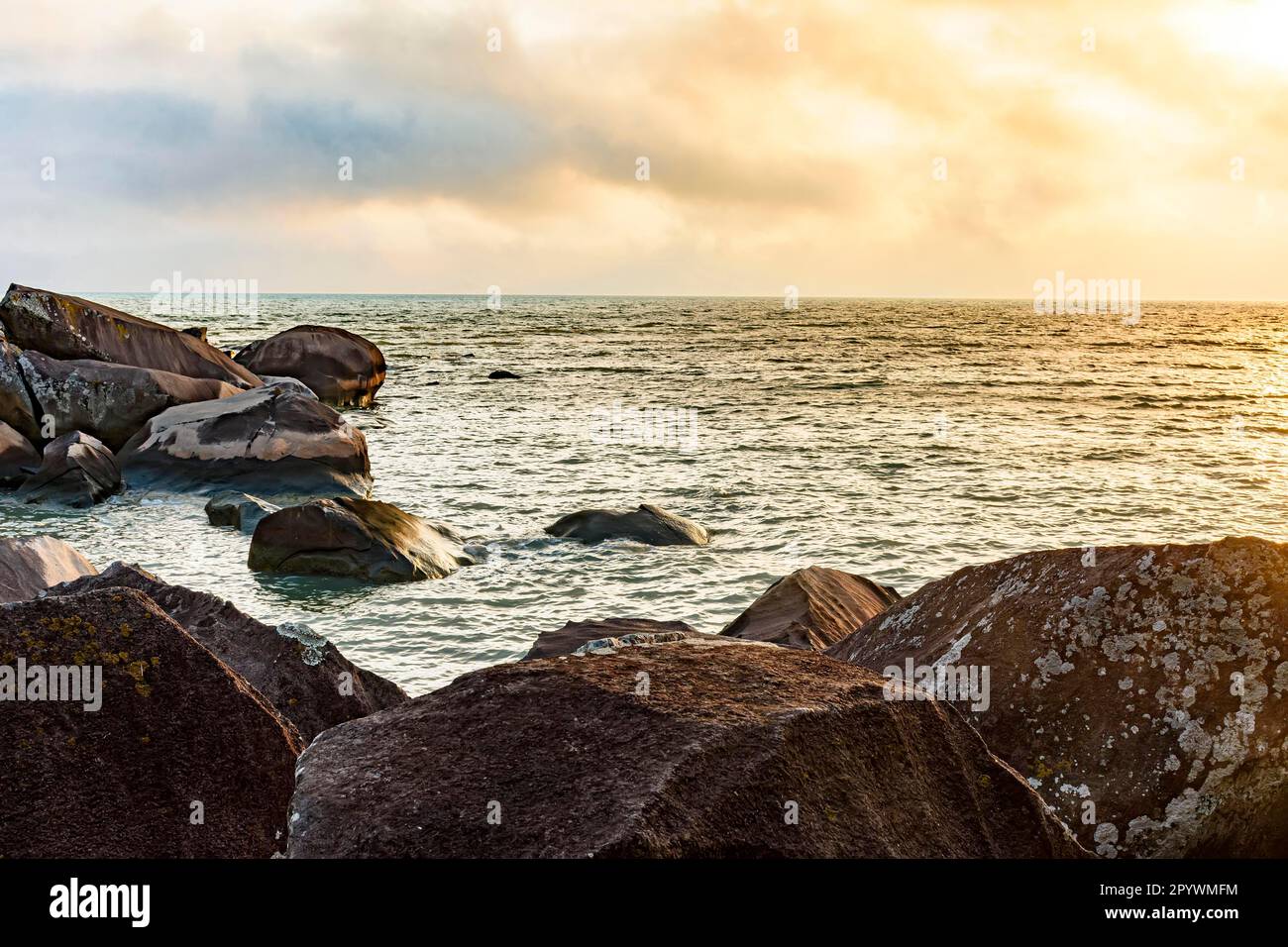 Sunset at the sea of Ilhabela island with the ocean, horizon and stones ...
