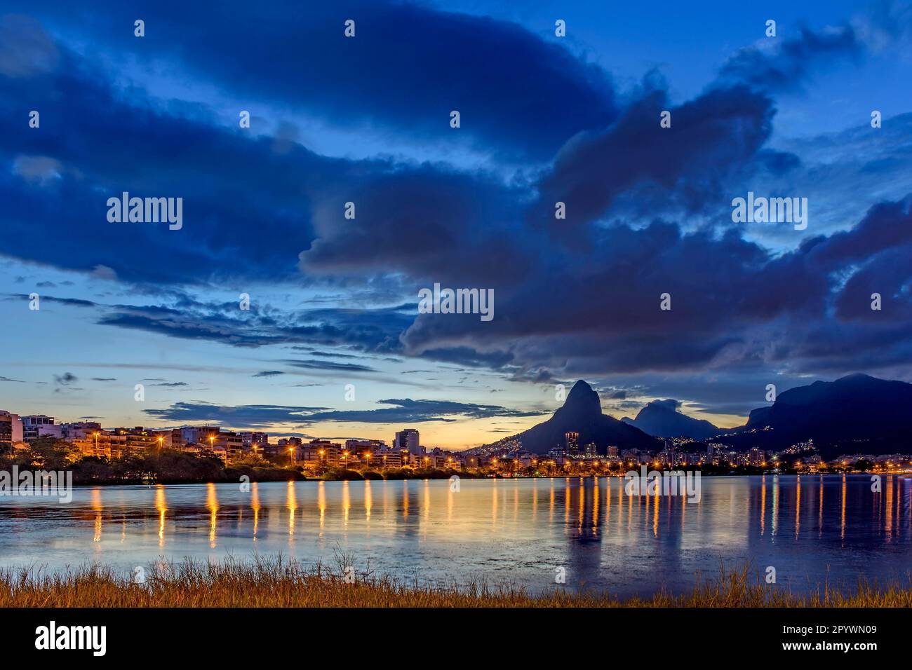 Dusk at Rodrigo de Freitas lagoon with the buildings, hills and lights ...