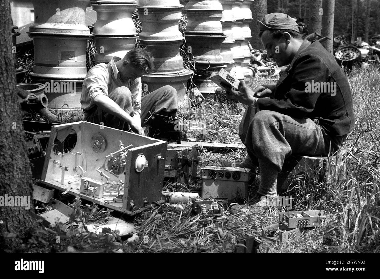 Two men cannibalize military radios and look for anything usable ...