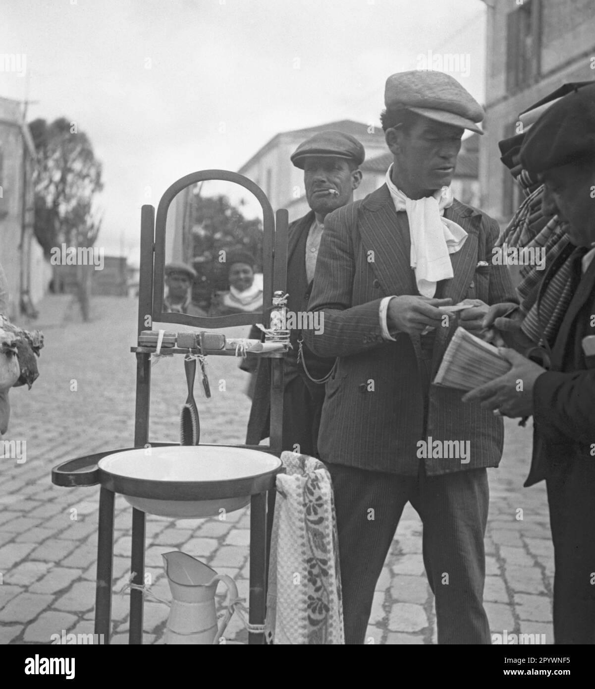 A barber has set up his stall on a street in Tetouan. He offers shaves ...
