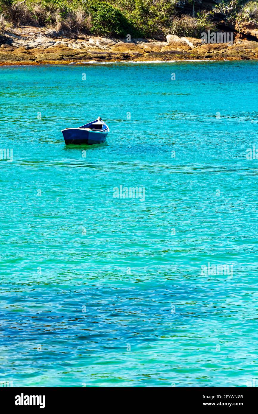 Old wooden fishing boat floating on the colorful and transparent waters ...