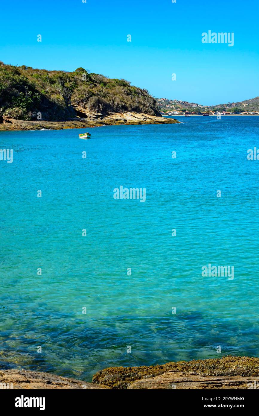 Small wooden fishing boat on the turquoise waters of Buzios on the ...