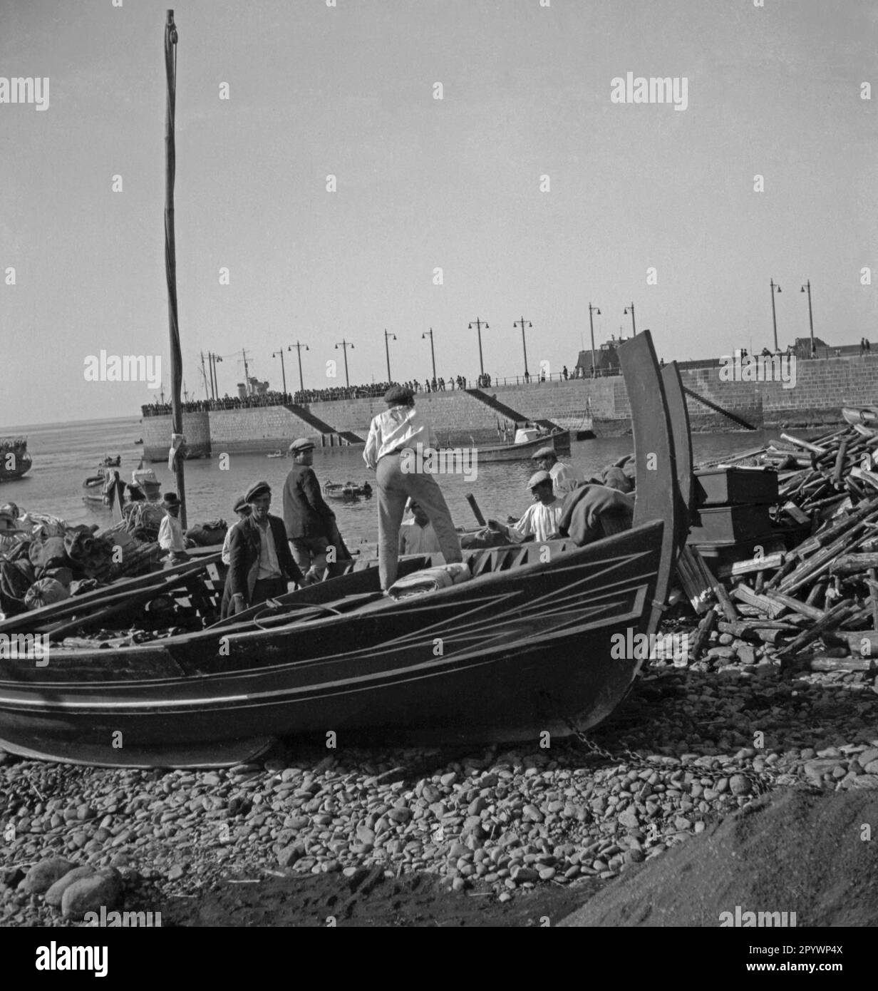 Men load a ship on the beach of Madeira Stock Photo - Alamy