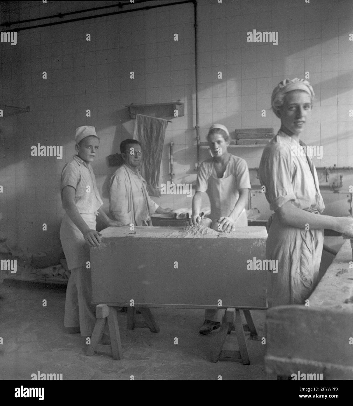 Employees of the industrial bakery Wittler Brot preparing dough. After ...
