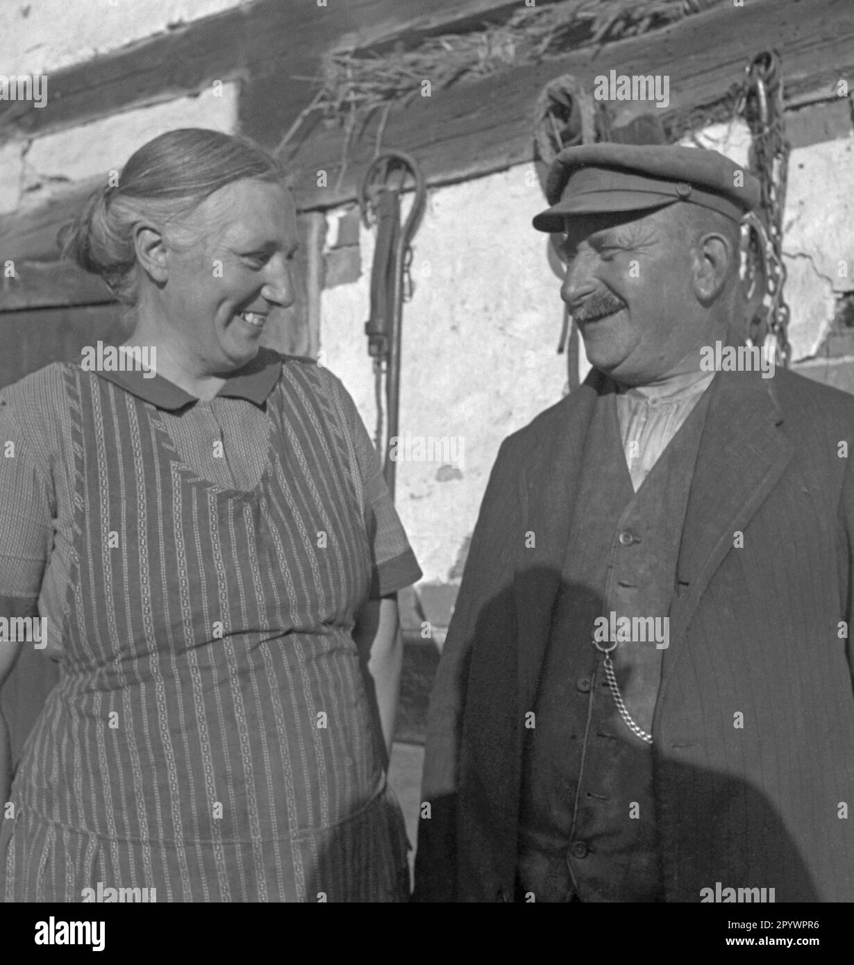 A farmer and his wife look at each other smiling. Undated photo ...
