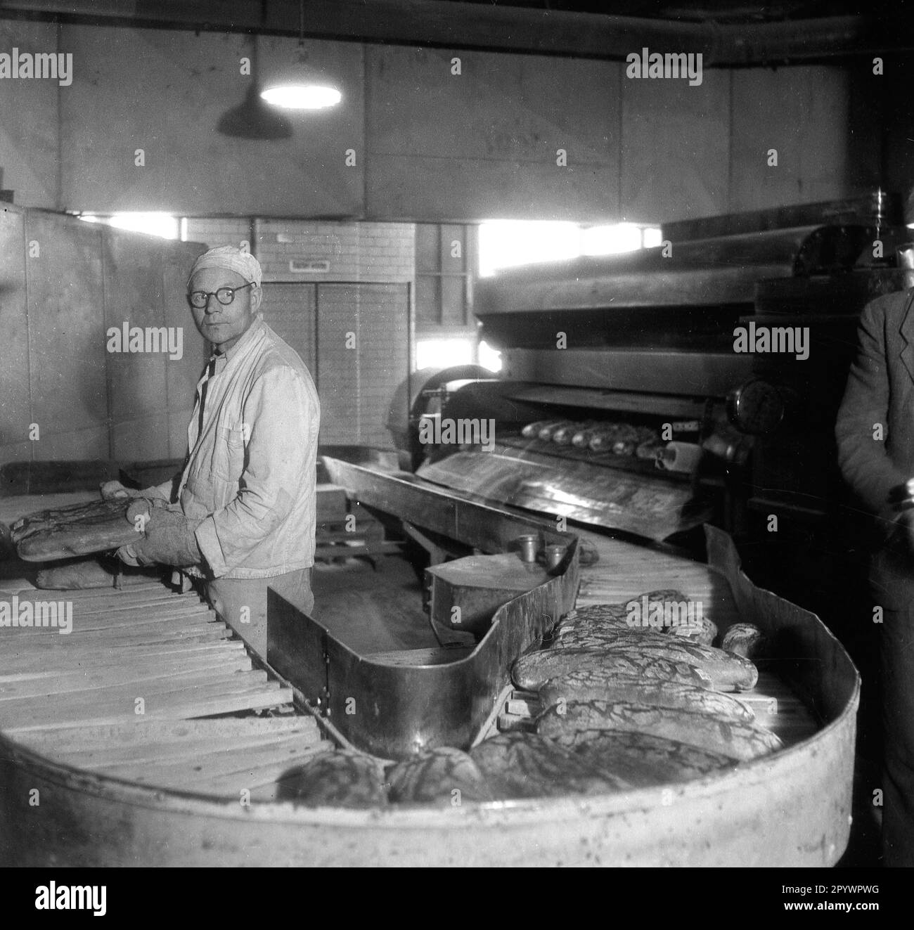 An employee of the industrial bakery Wittler Brot takes ready loaves of ...
