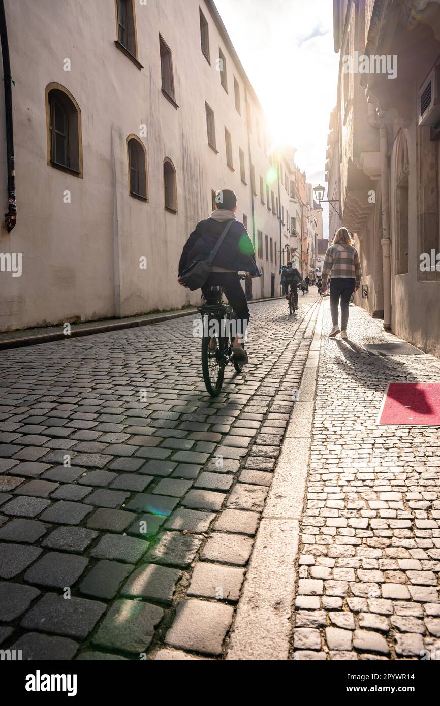 Busy alleyway alley in the light of the evening sun, Regensburg ...