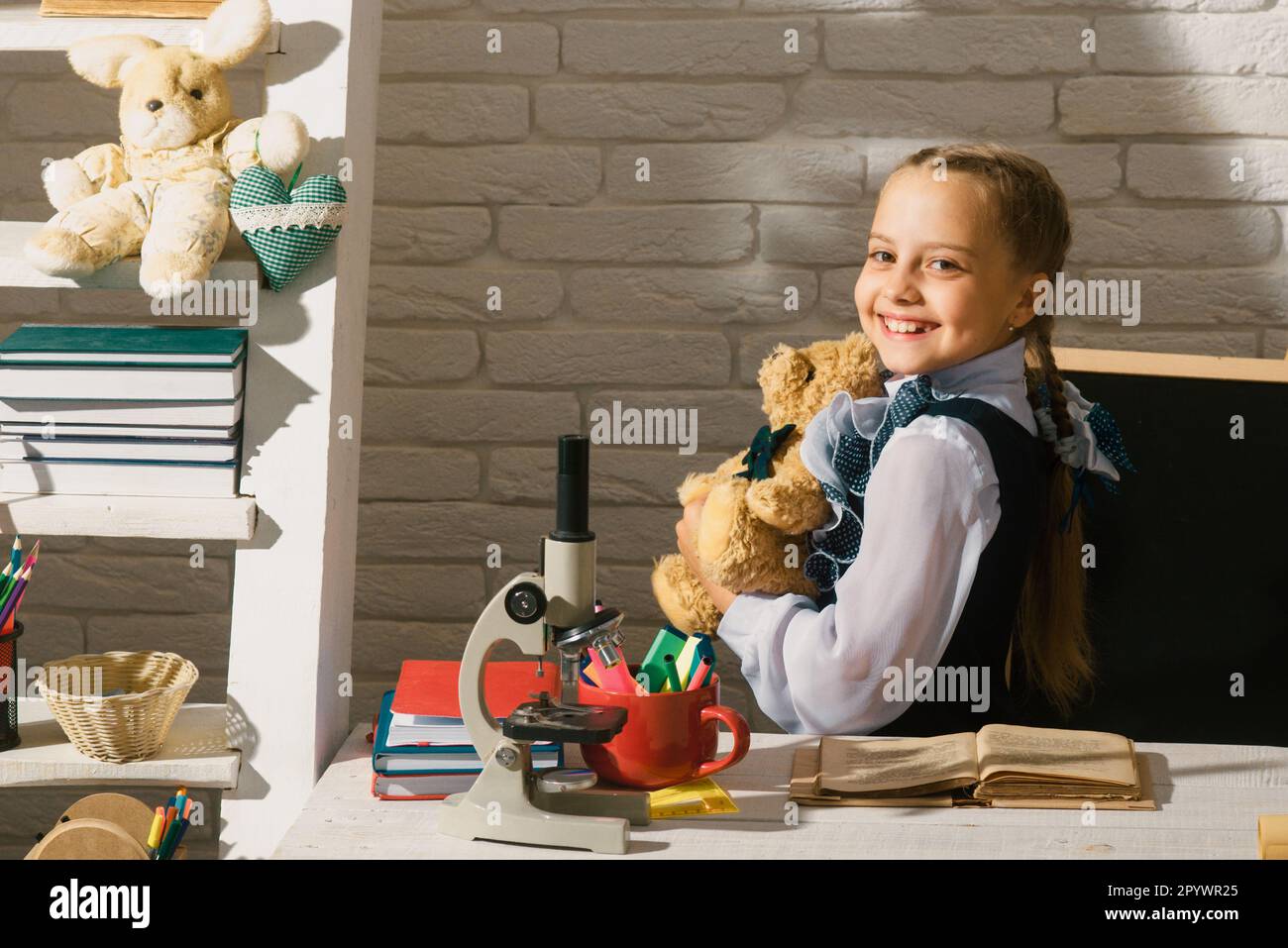 School kid girl hold toy teddy bear. Child is learning in class. Pupil ...
