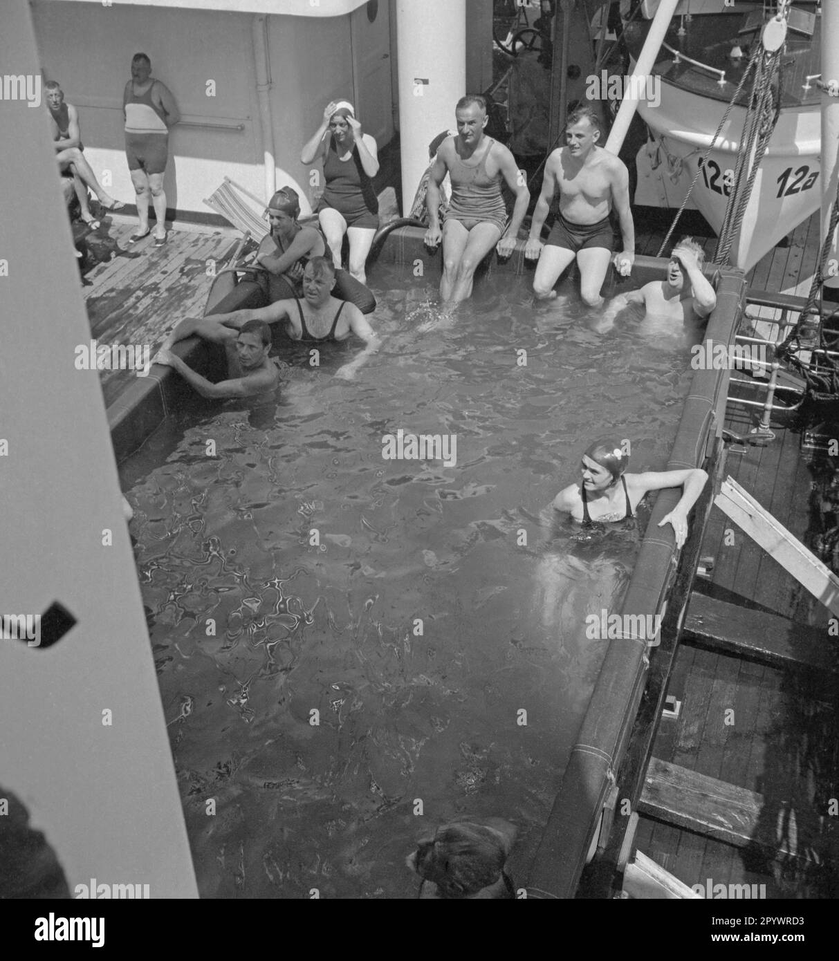 Passengers in the swimming pool on the upper deck of a passenger ship ...