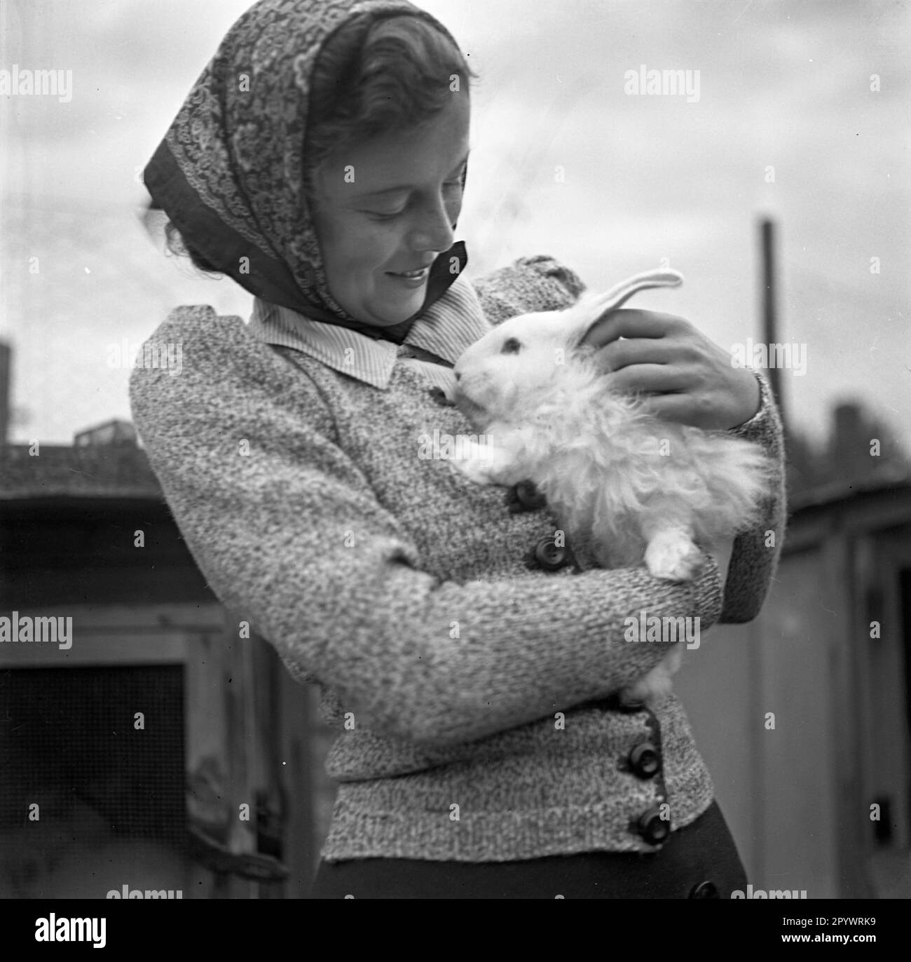 Young woman with rabbit. Location and date unknown, probably in the ...