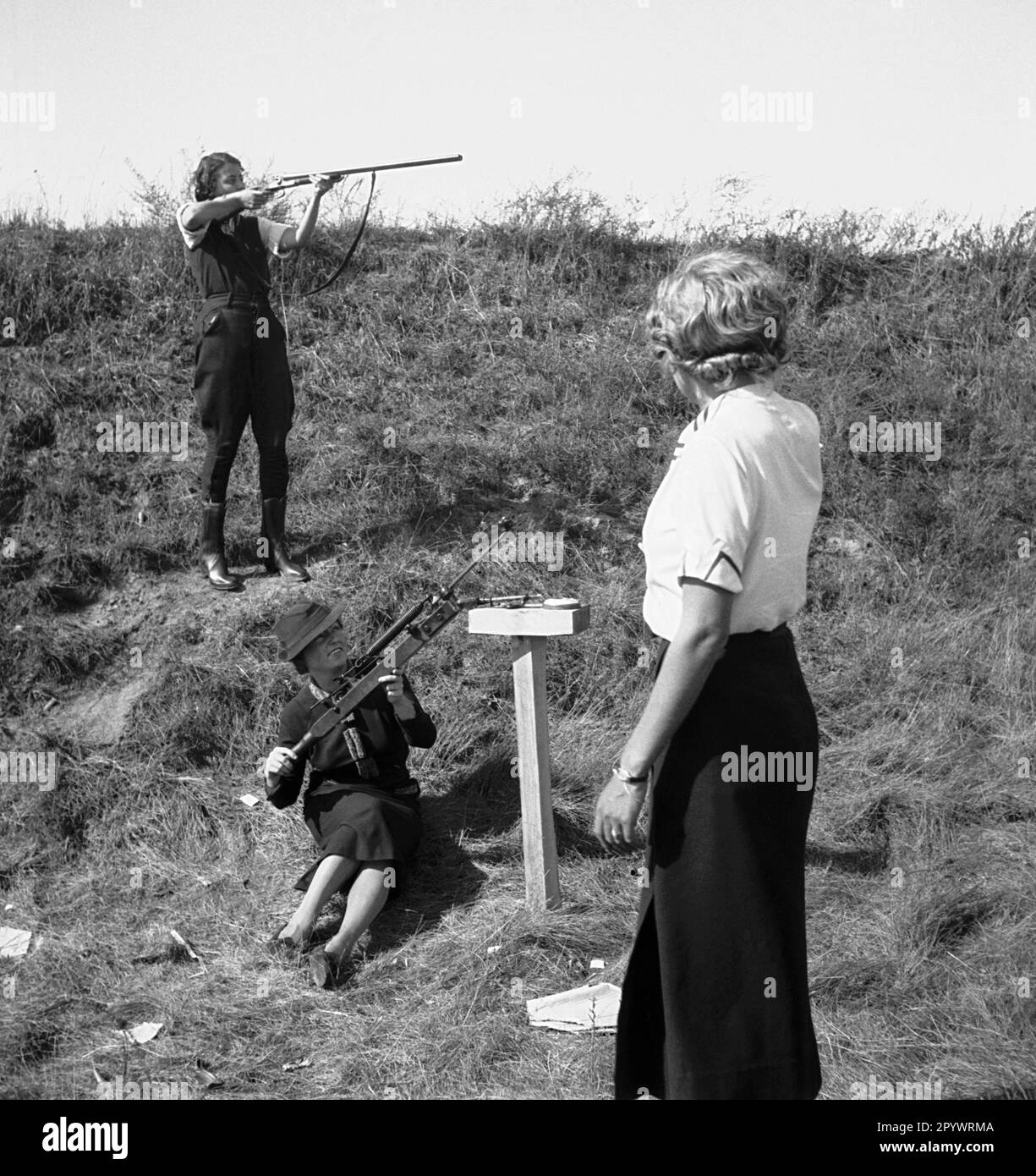 Three women are practicing shotgun shooting. While one of them is ...