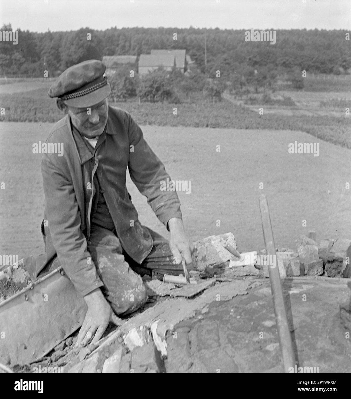 Man repairing a tar kiln for pyrolytic decomposition in Mecklenburg. In ...