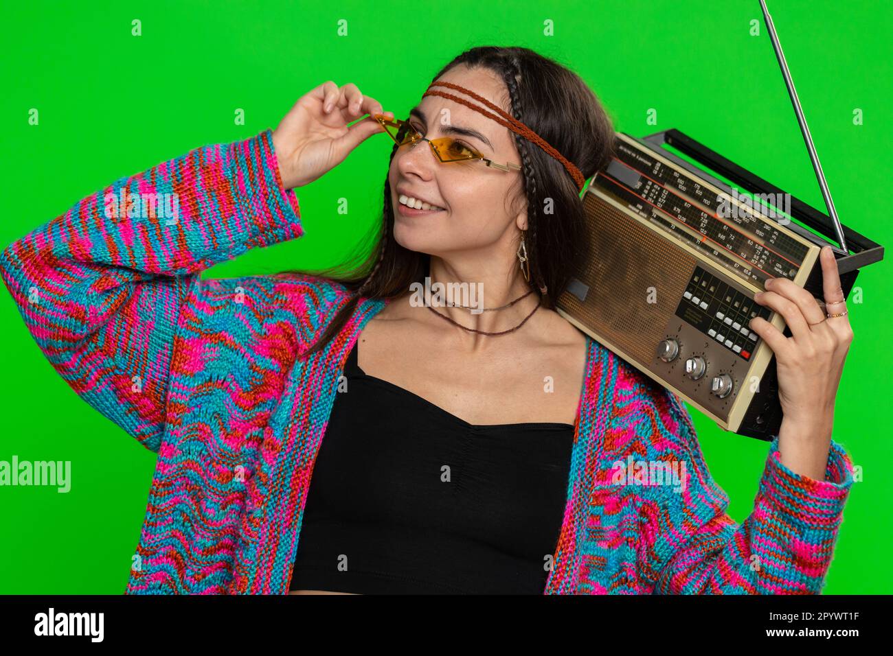 Woman in sunglasses using retro tape record player to listen music ...