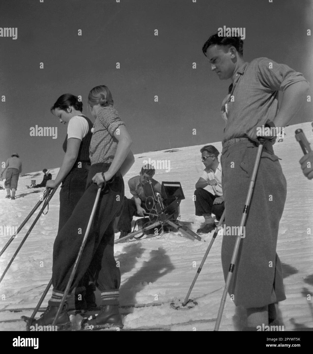 A cameraman sets his camera. Actors and extras are waiting for their ...