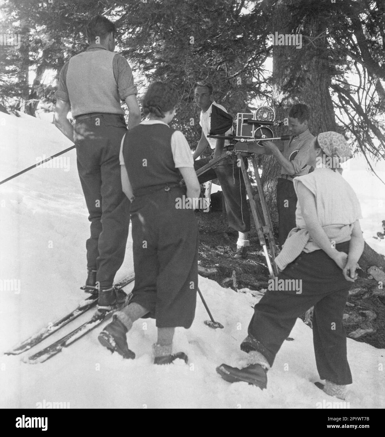 A cameraman sets his camera. Actors and extras are waiting for their ...