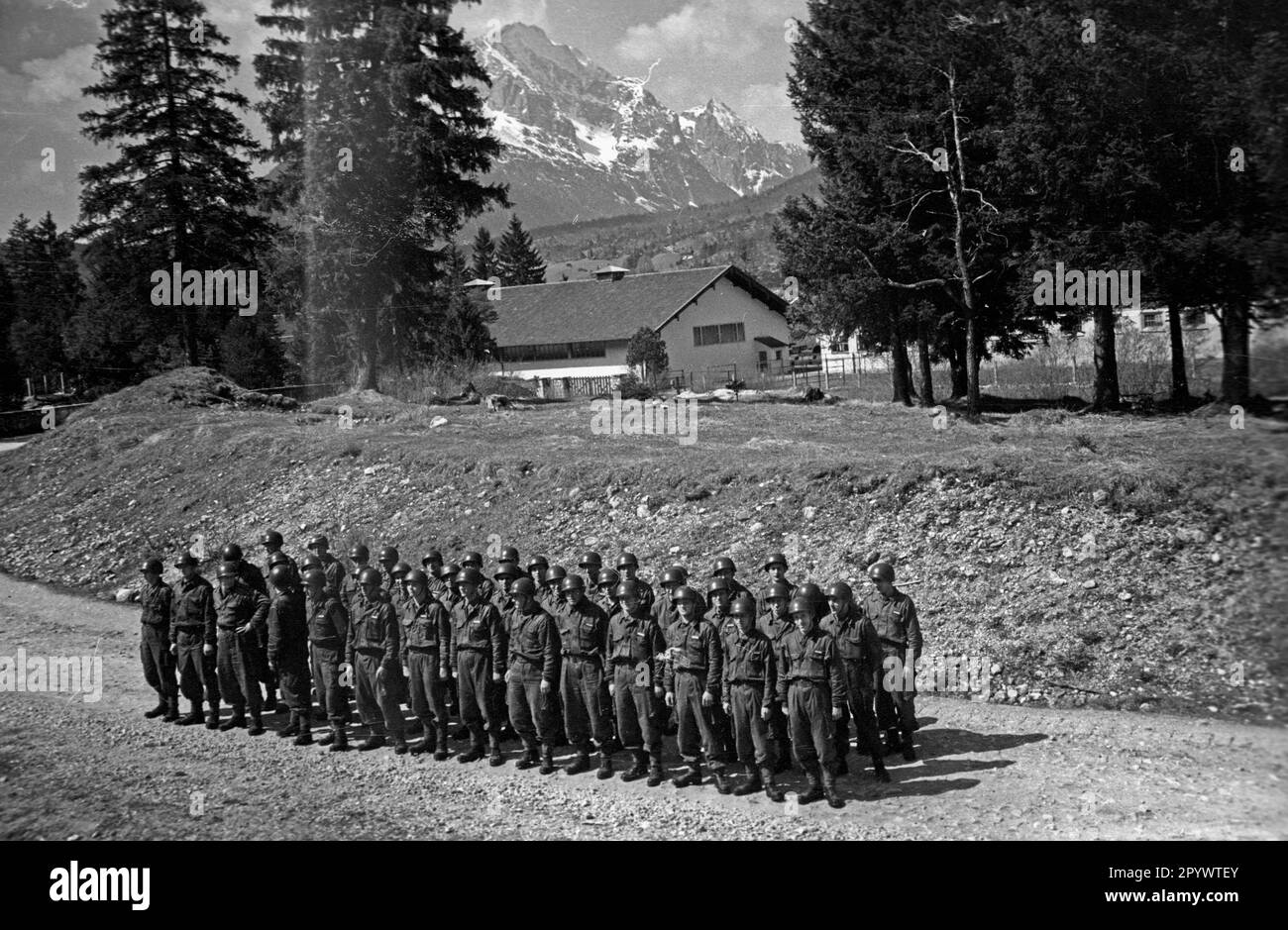 Soldiers of a Gebirgsjaeger platoon have lined up. The soldiers wear rumpled work clothes ...
