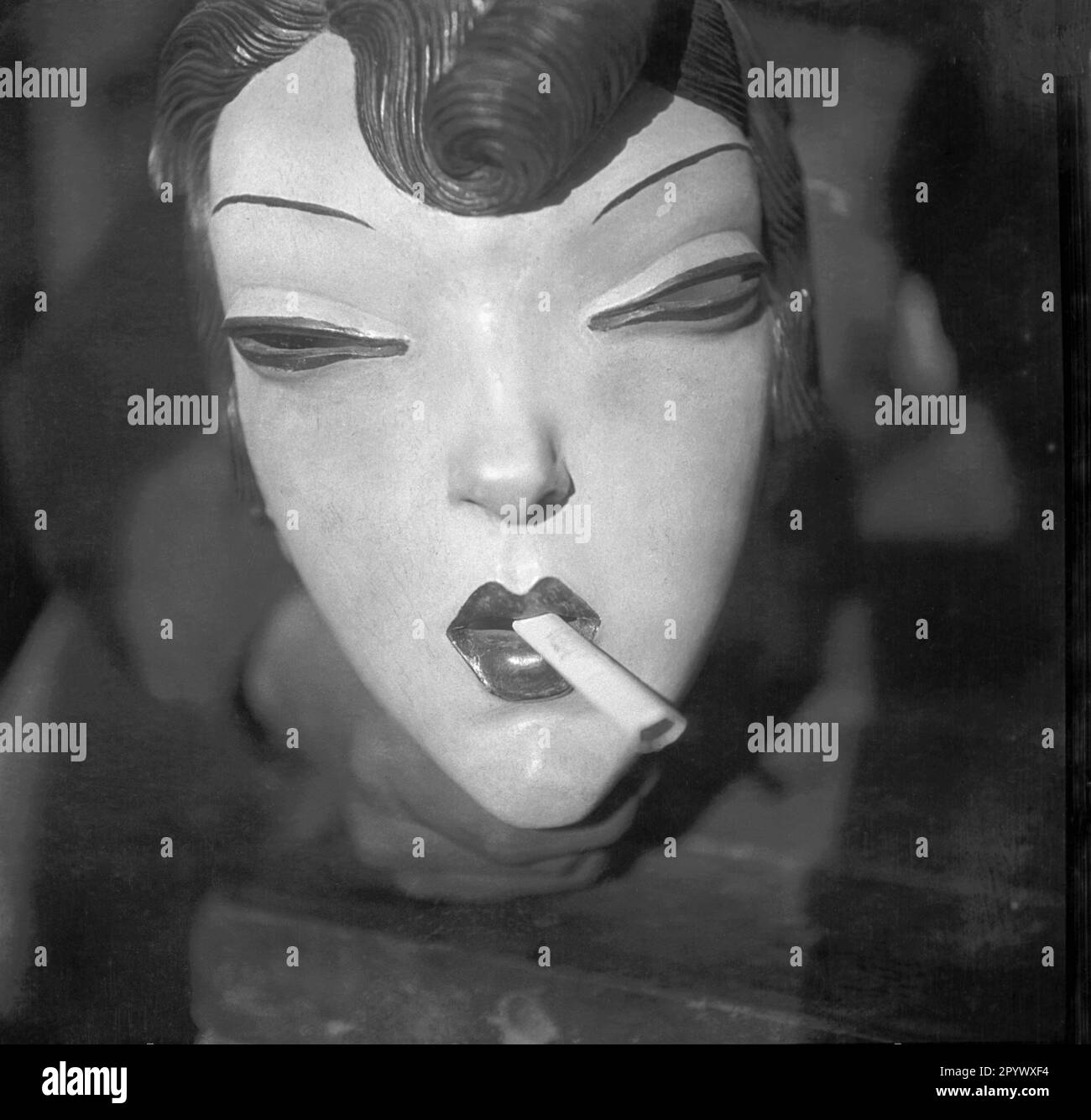 Hand-carved, painted wooden mask in the shape of a woman's face in a ...