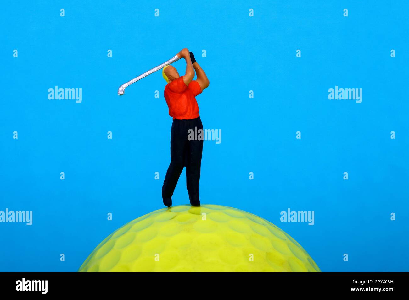 Miniature figure golfer teeing off from a golf ball Stock Photo - Alamy
