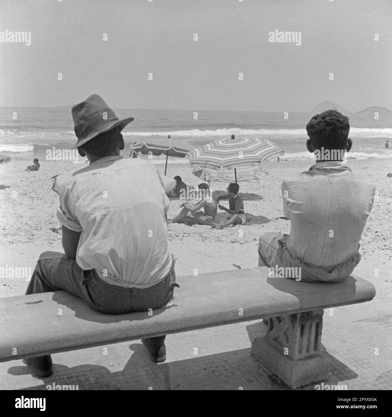 Two Brazilian boys sitting on a bench on the beach (presumably on the ...