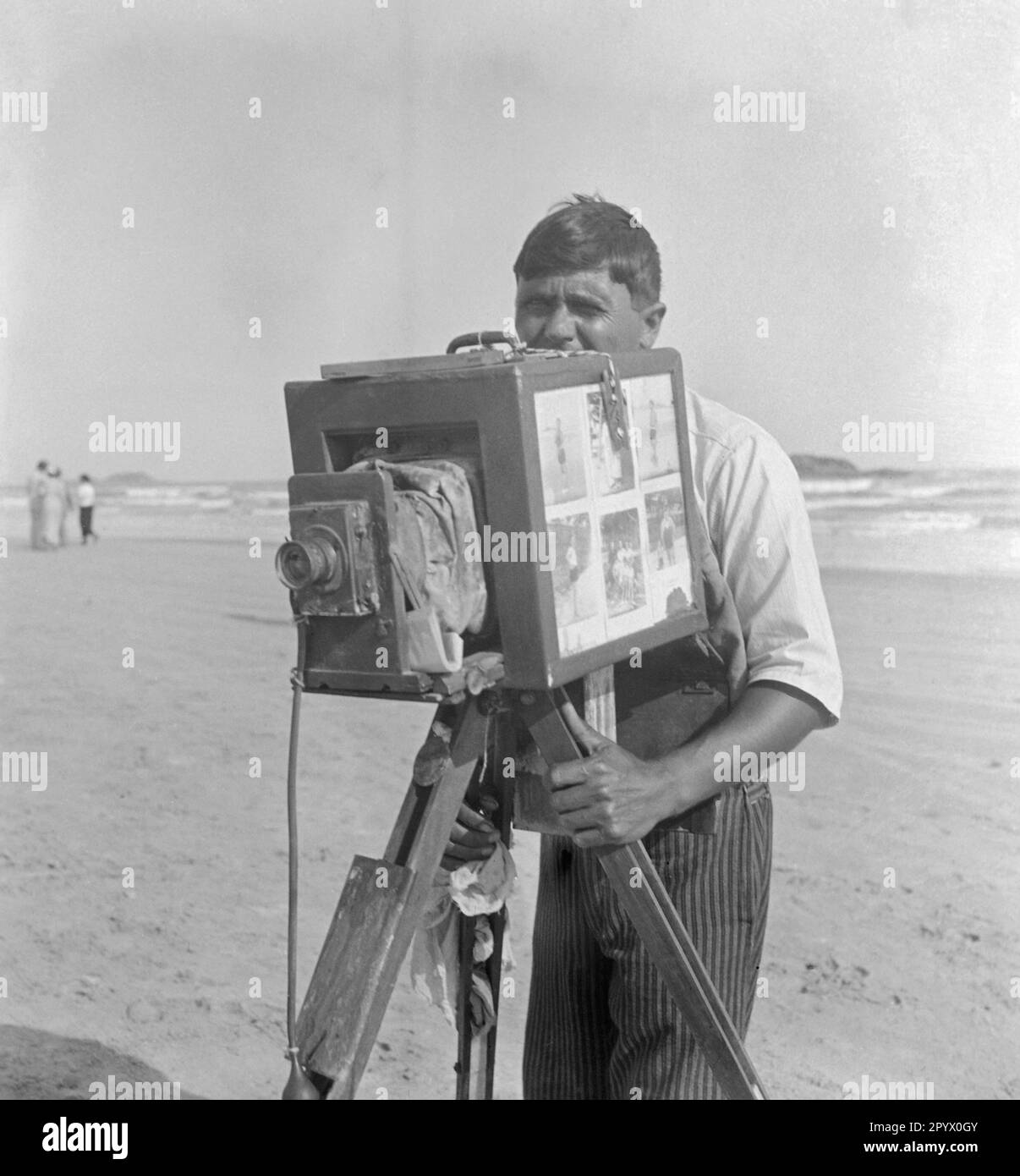 A Brazilian photographer with his old camera on the beach of Rio Stock ...