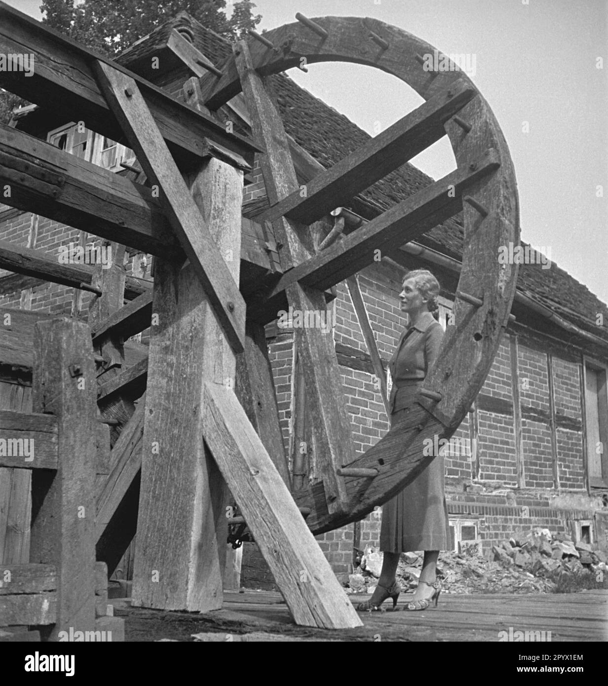 Woman beside the wheel of an eel trap. The wheel is used to catch the ...