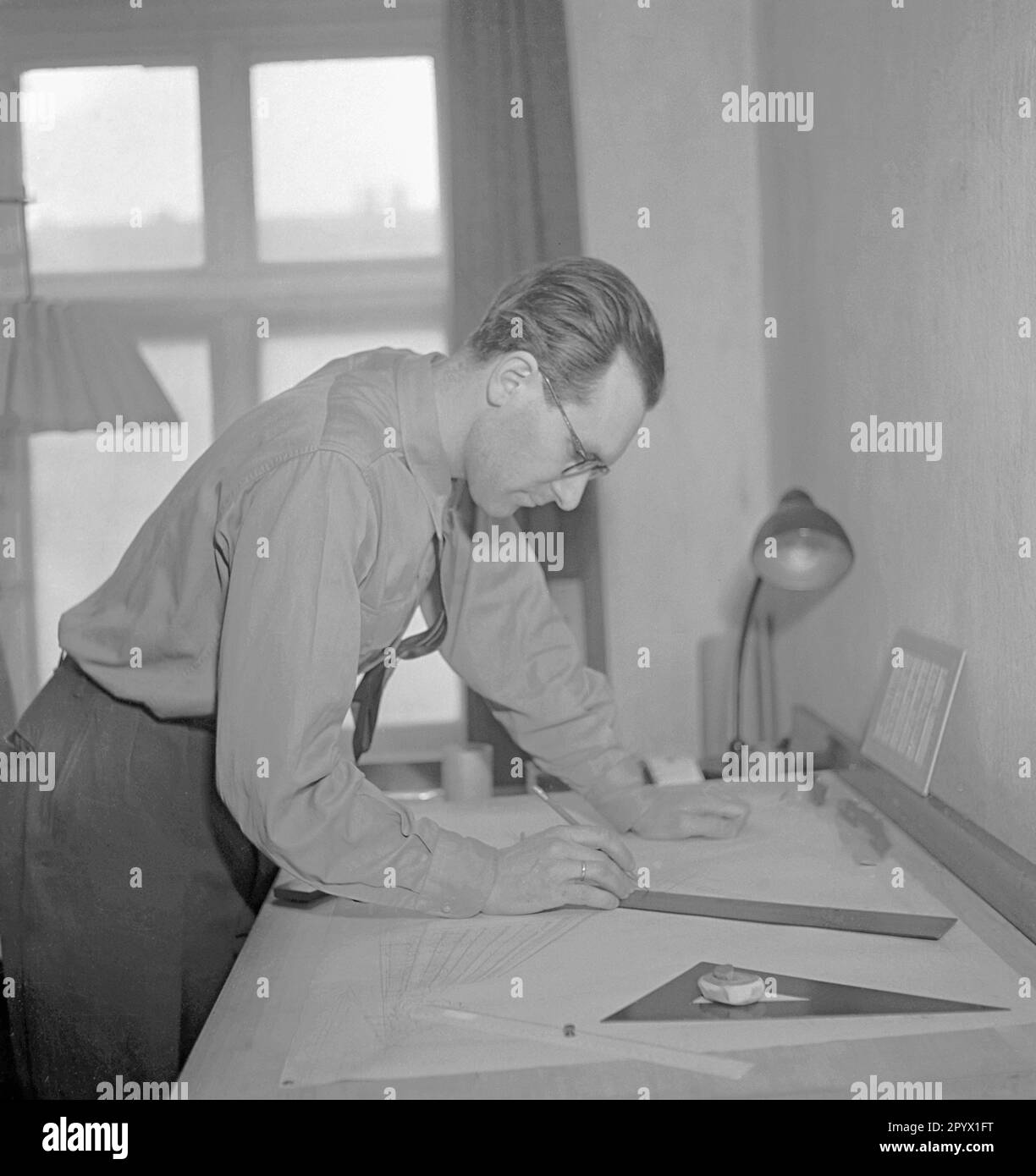 "An architect works on a technical drawing with a ruler, pencil and ...
