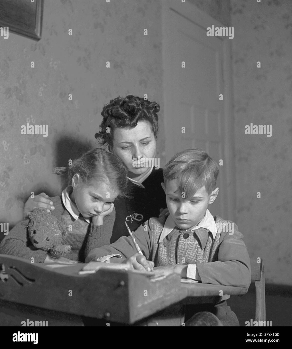 Mother helps son Black and White Stock Photos & Images - Alamy