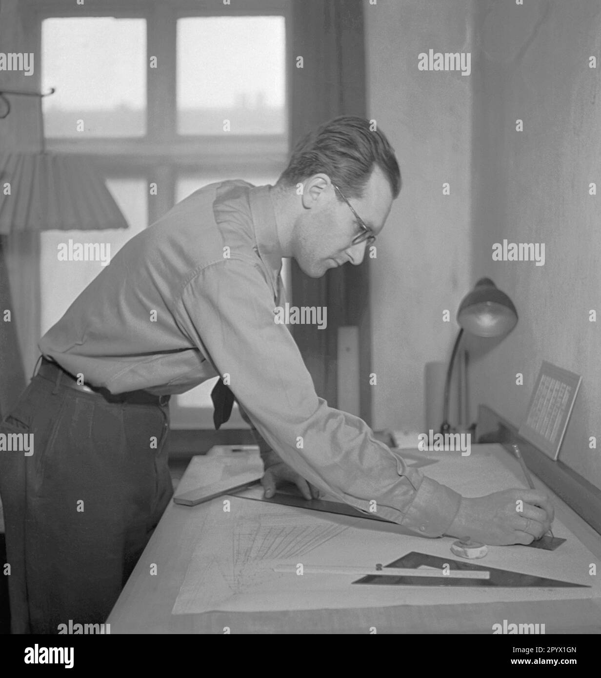 "An architect works on a technical drawing with a ruler, pencil and ...