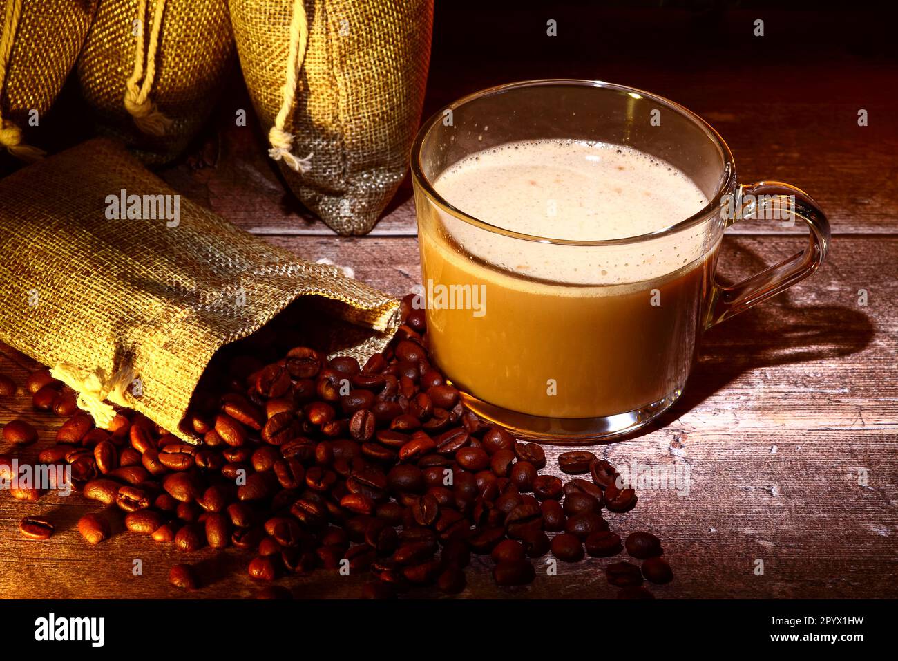 Glass coffee cup with sacks of raw roasted coffee beans Stock Photo - Alamy