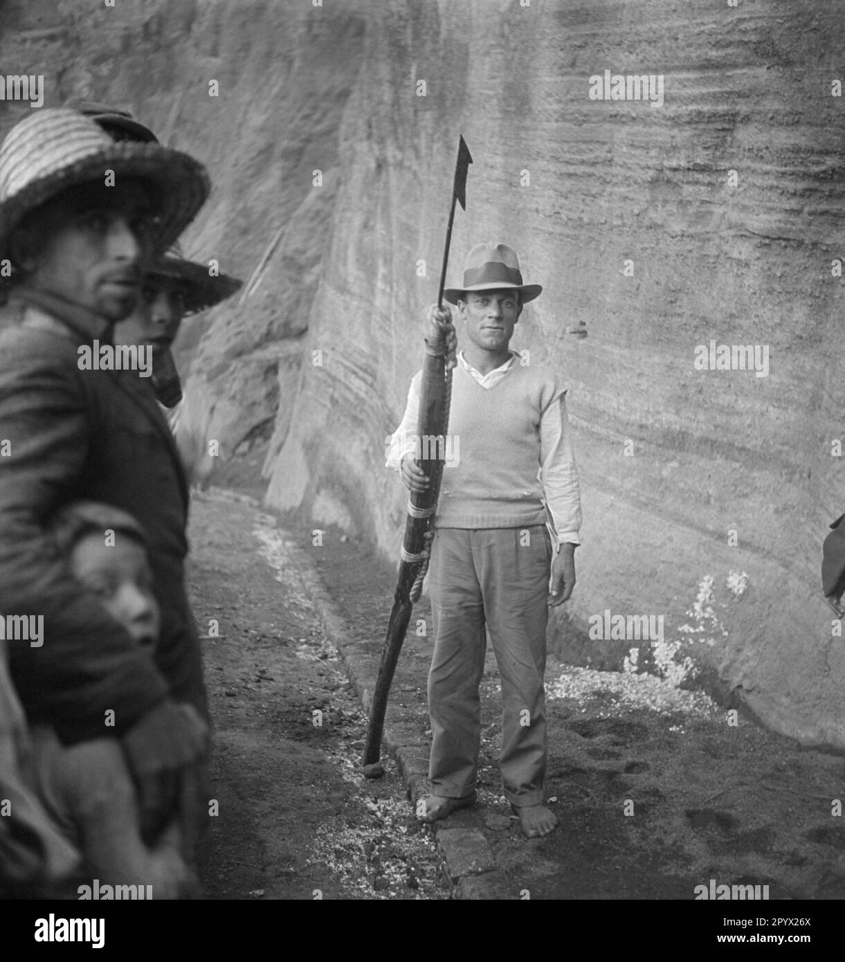 A man poses with a whale harpoon. Undated shot, probably taken in Ponta ...