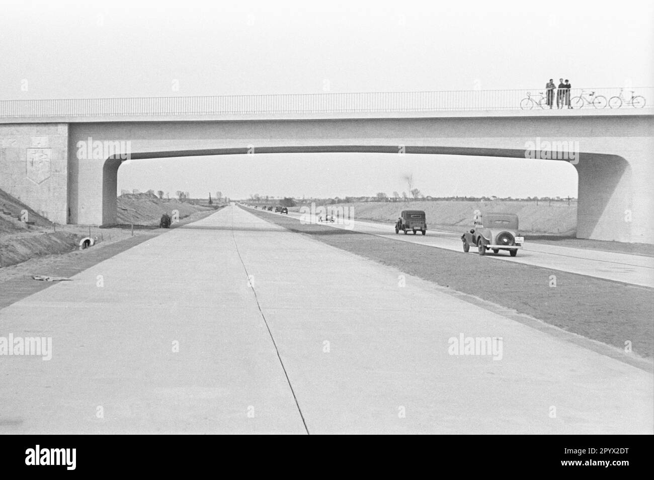 Cars pass through a bridge on the Berlin - Szczecin motorway. Onlookers ...