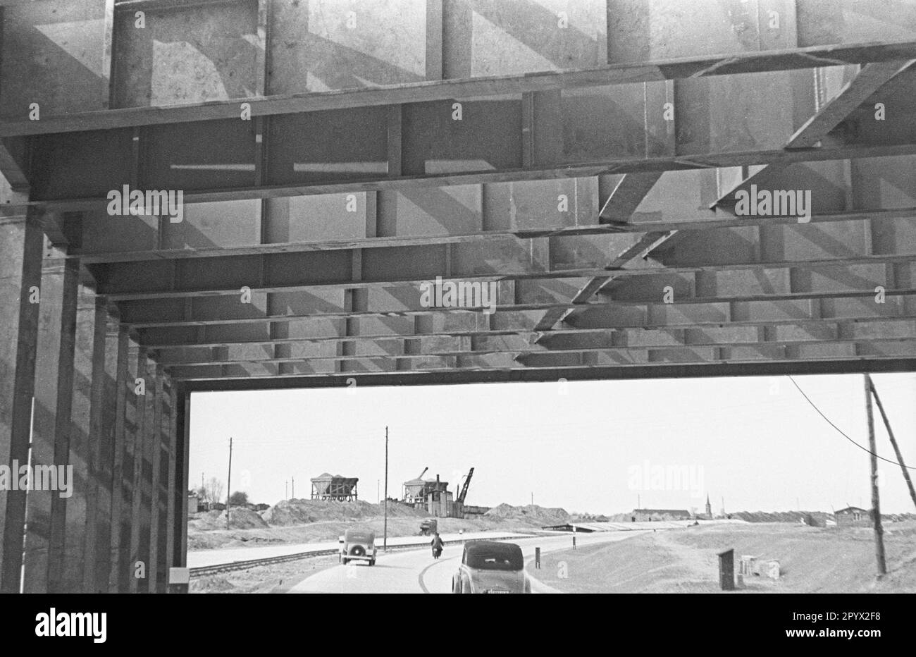 Transit under a bridge. In the background, ongoing construction work ...