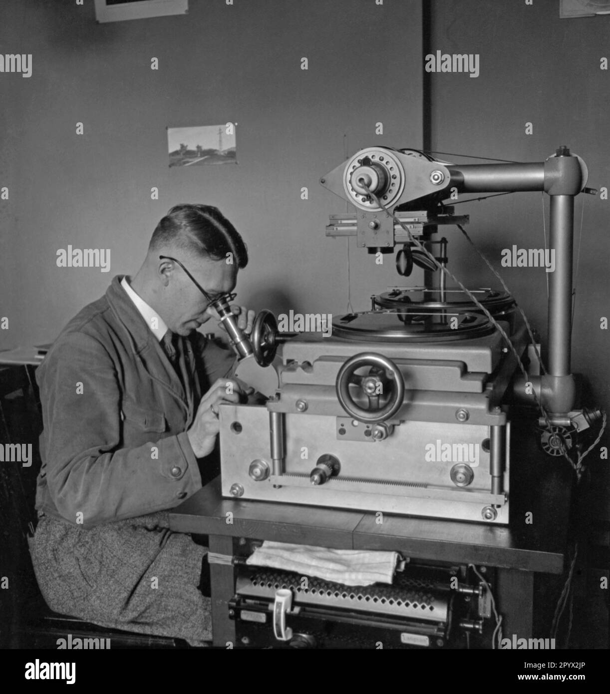 Employee evaluates the photos of the cameras. Undated photo, probably ...