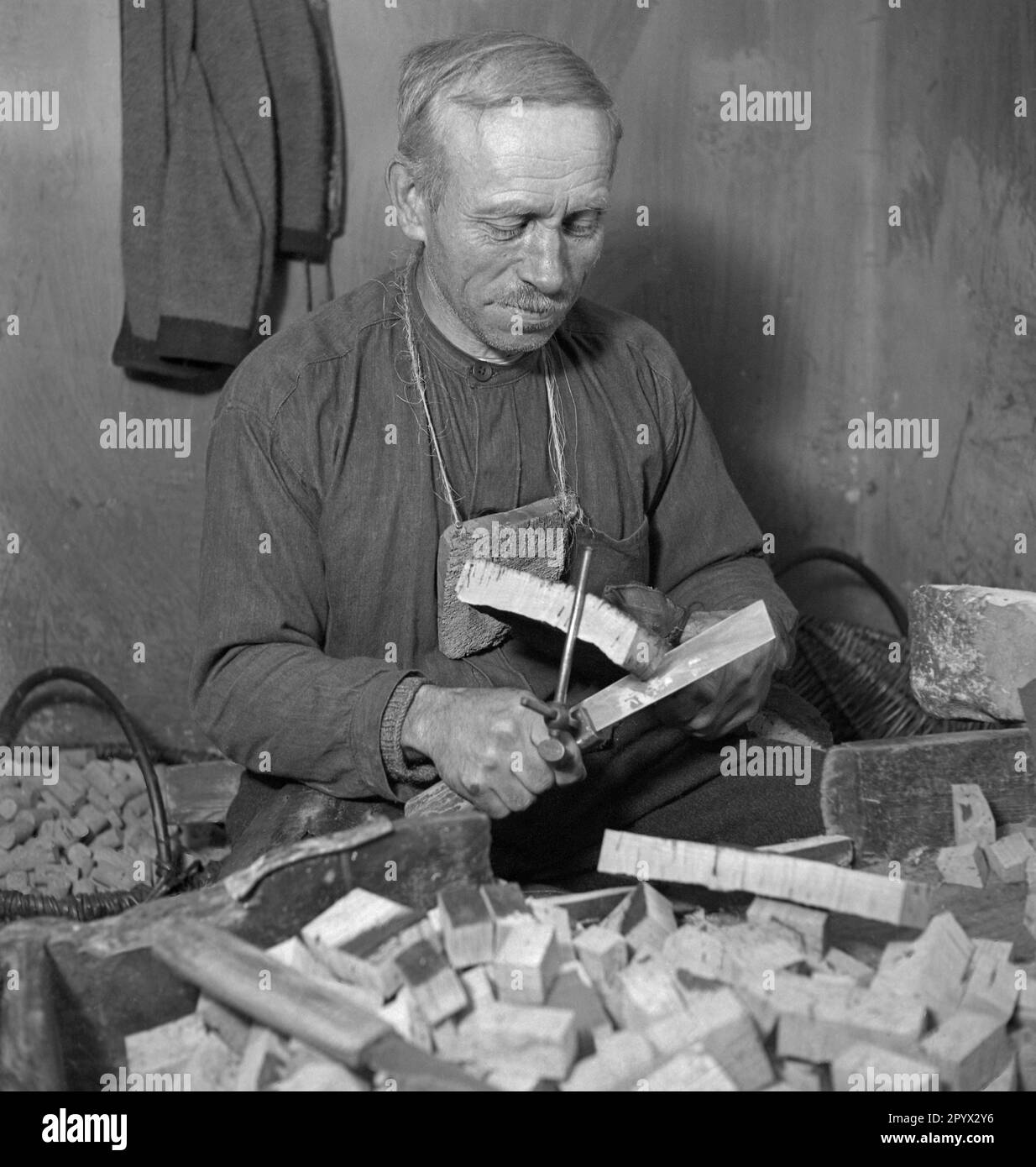 Cork maker at work. Here he is cutting the cork sheets into smaller ...