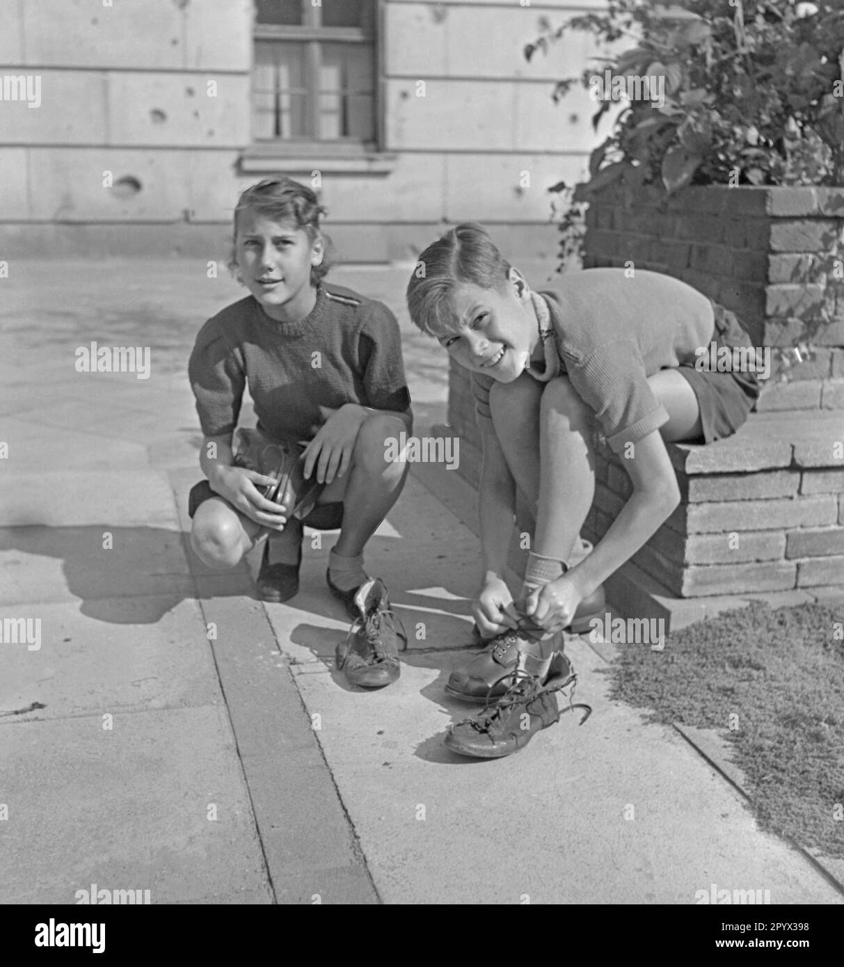 Two boys try on their new shoes during a shoe distribution of the ...