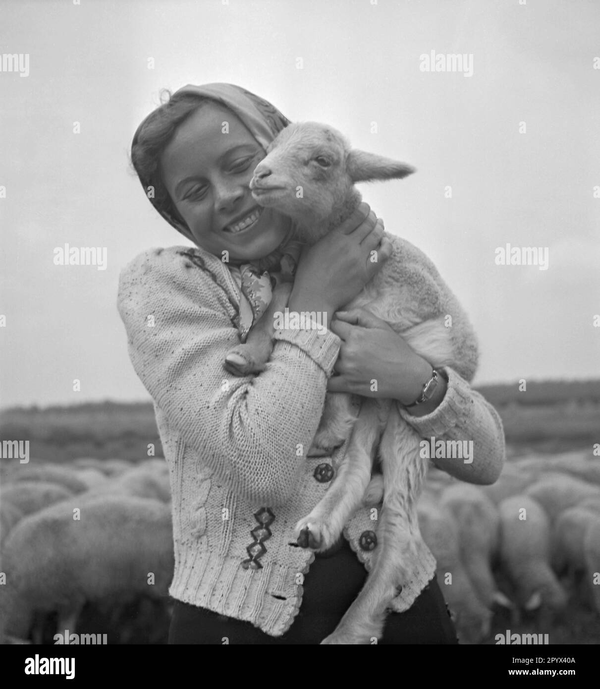 A young woman holds a lamb in her arms, probably at the market in Zetel ...