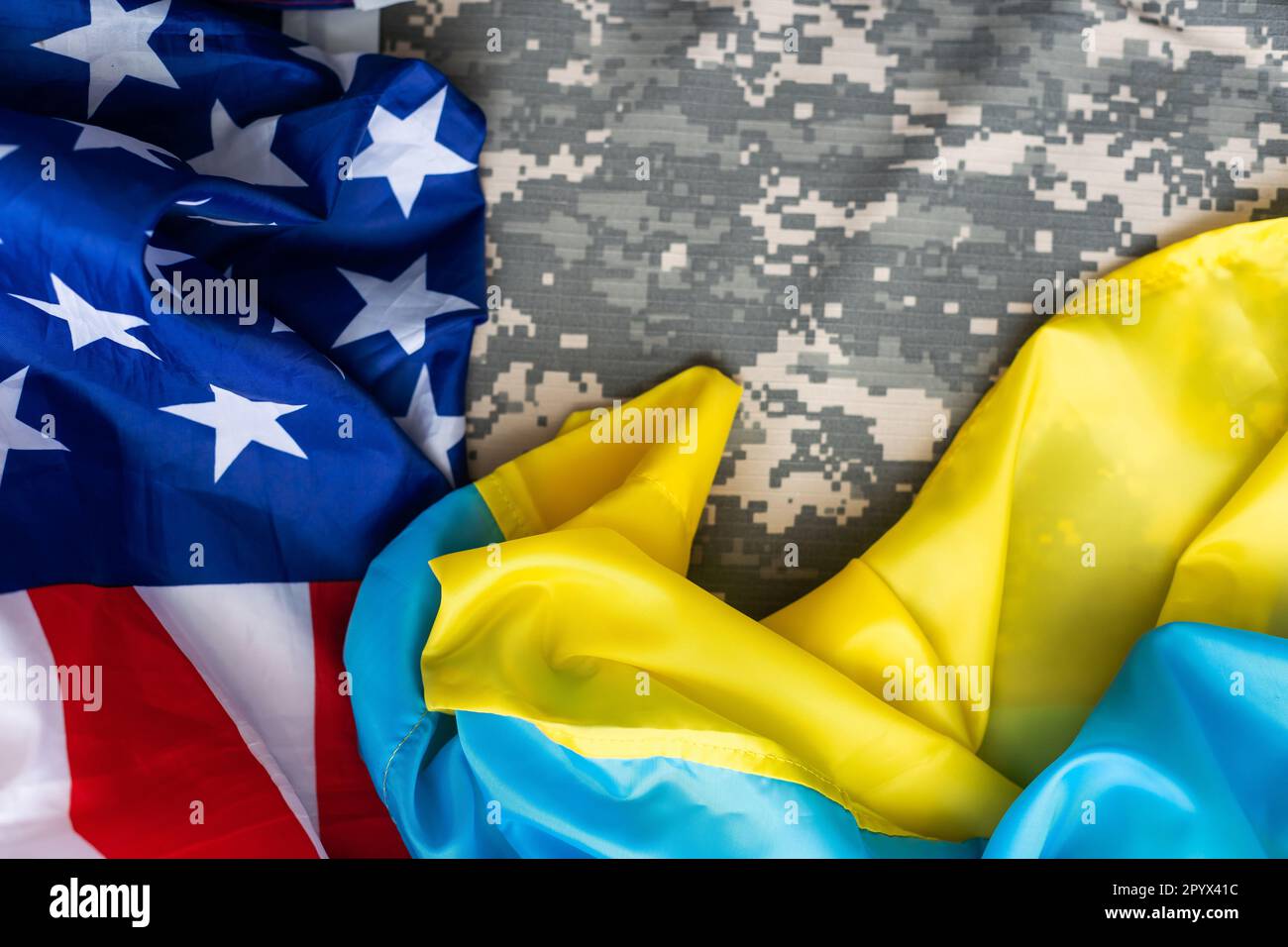 American Flag on Soldiers arm and flag of the Ukraine at background. US ...
