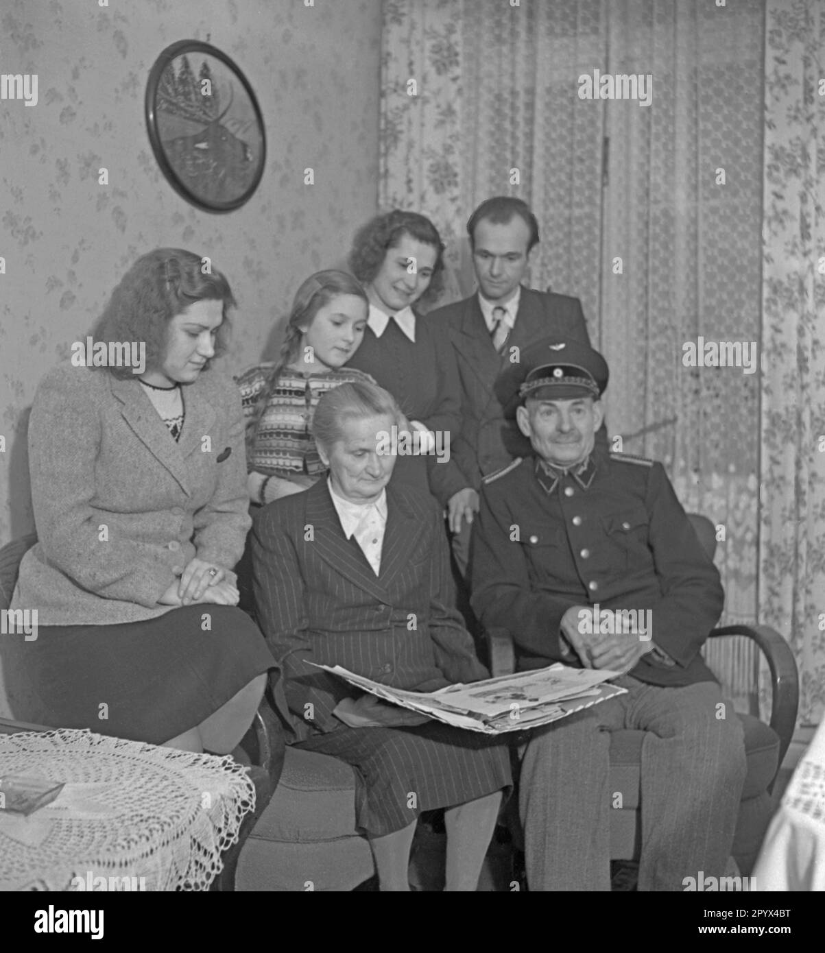 Undated photo. In 1950, a family in a living room in Berlin is watching ...