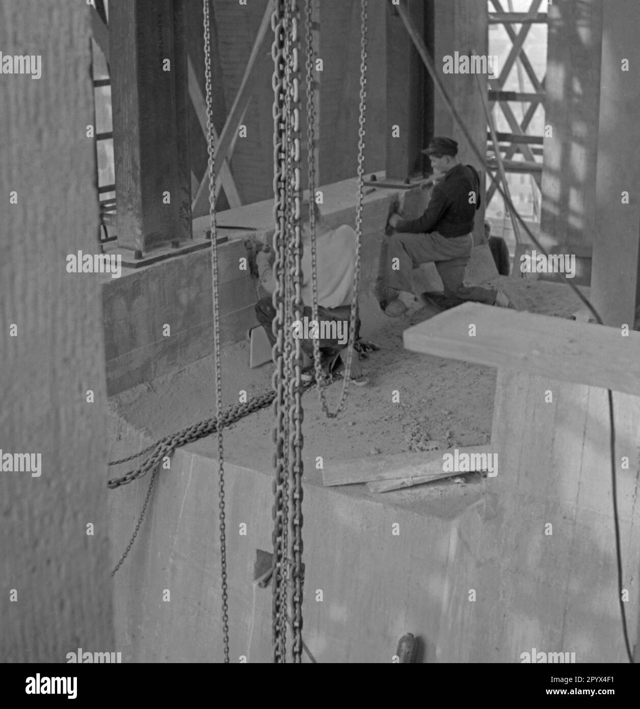 Photo of two construction workers on the tower scaffolding of Rathaus ...
