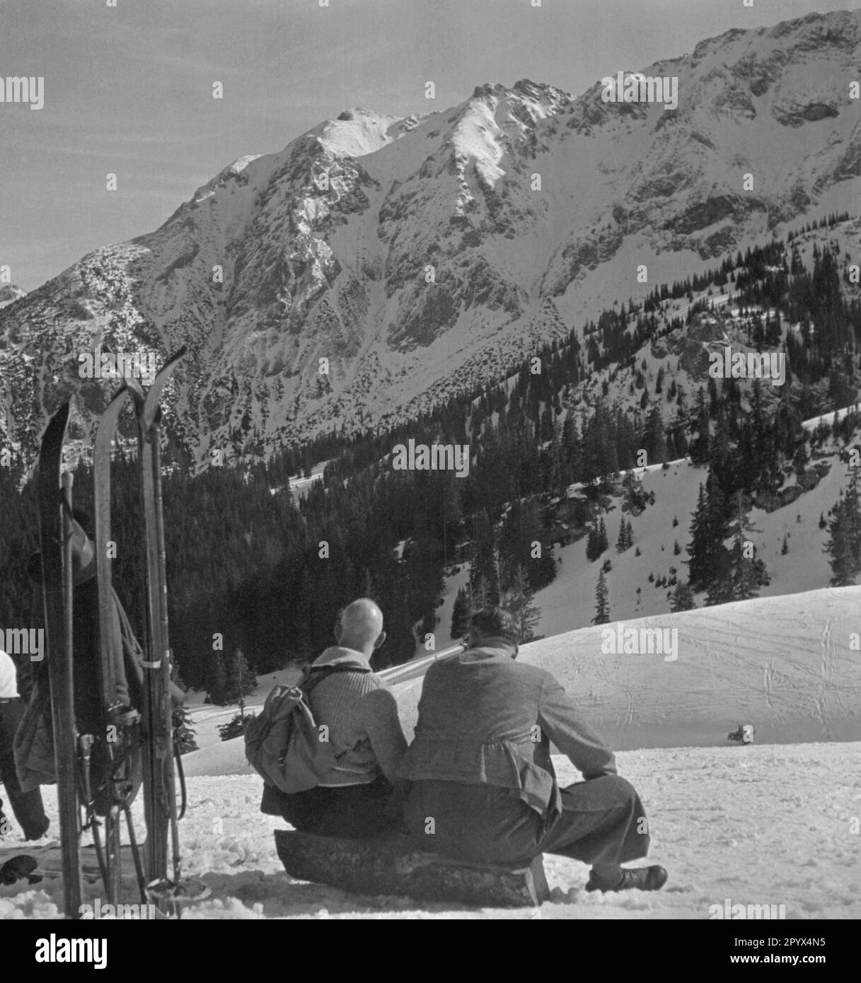 "Two skiers look at the alpine landscape on a high alpine pasture at a ...